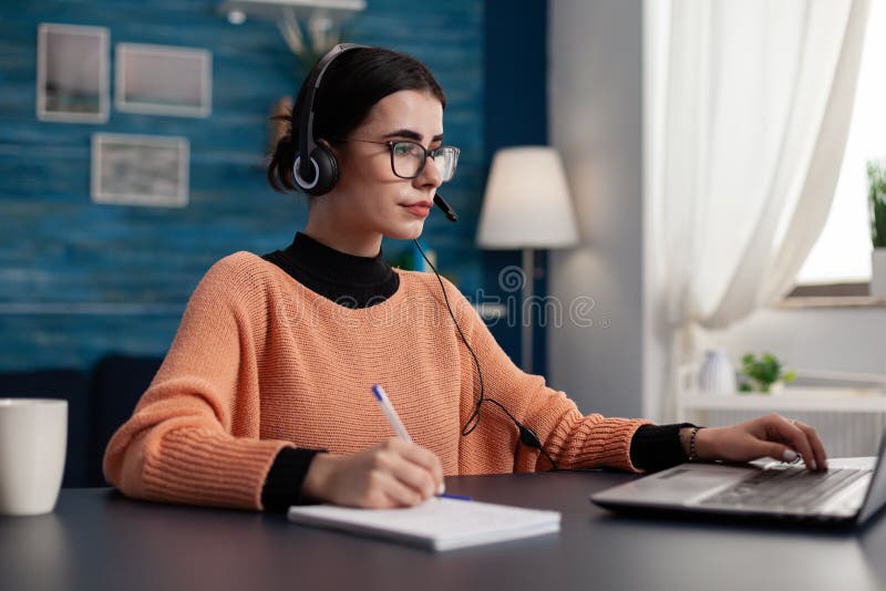 Student with Headphones Taking Notes in Online Class. Stock Image ...