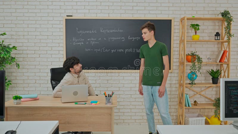 Student and Instructor Discuss Python Code in Modern Classroom Stock ...