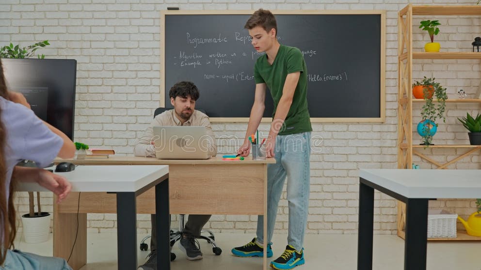 Student and Instructor Discuss Python Code in Modern Classroom Stock ...