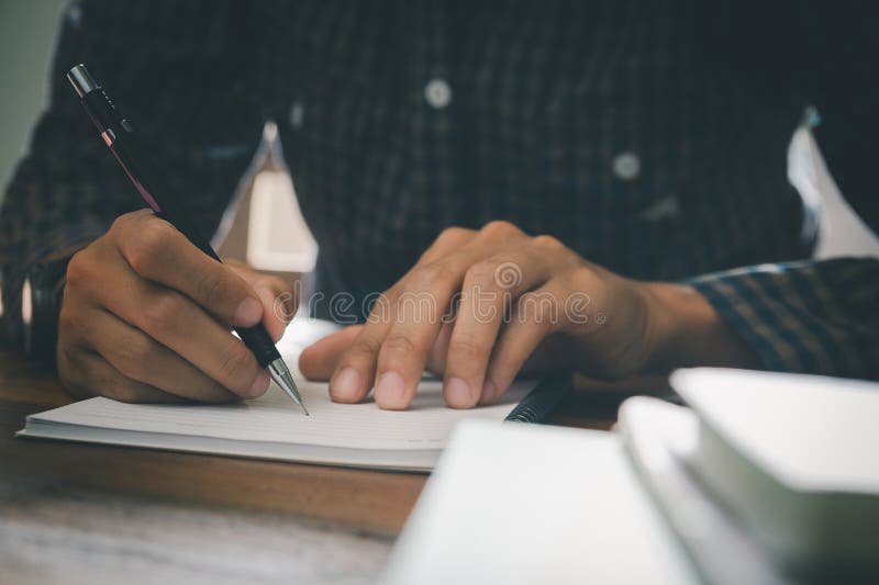 A Student Intensely Studying and Writing in a Notebook, Preparing for ...
