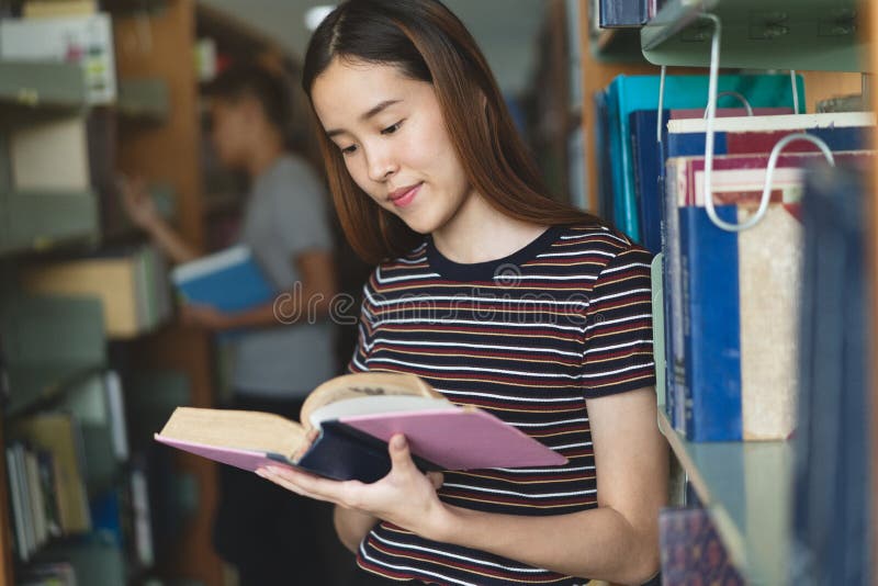 Student Learning in Library. Young Woman Read Book in Library for Doing ...