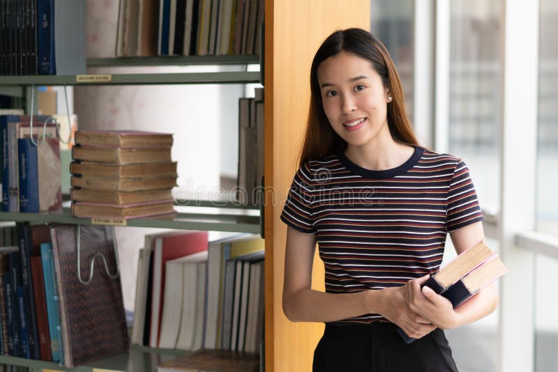 Student Learning in Library. Young Woman Read Book in Library for Doing ...