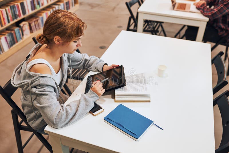 Student Learning in University Library. Young Woman Reading Textbook ...
