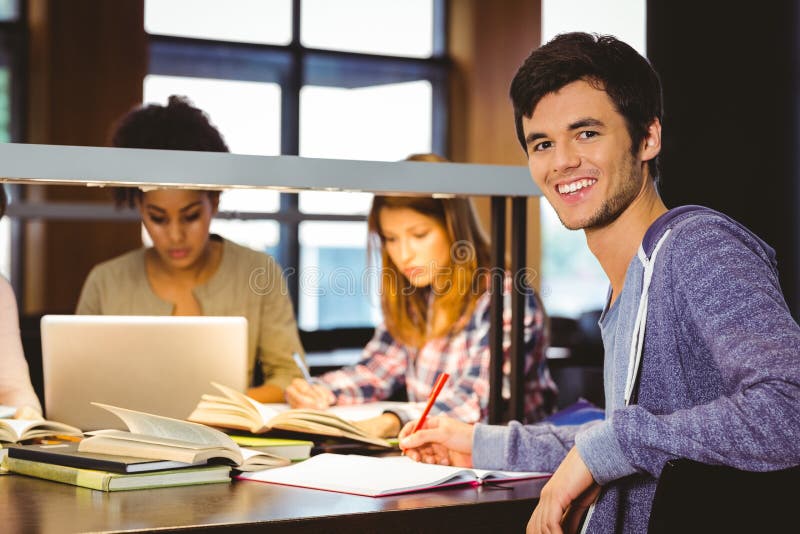 Student Looking at Camera while Studying with Classmates Stock Photo ...