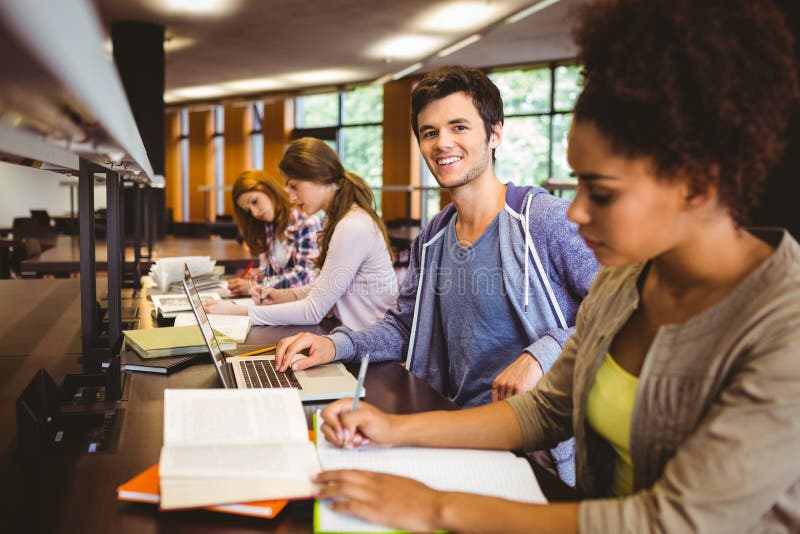 Student Looking at Camera while Studying with Classmates Stock Photo ...
