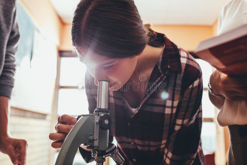 Student Looking through Microscope in Biology Class Stock Photo - Image ...