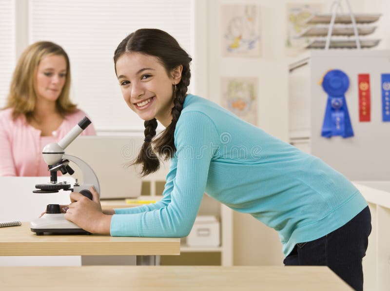 Student Looking into Microscope in Classroom Stock Photo - Image of ...