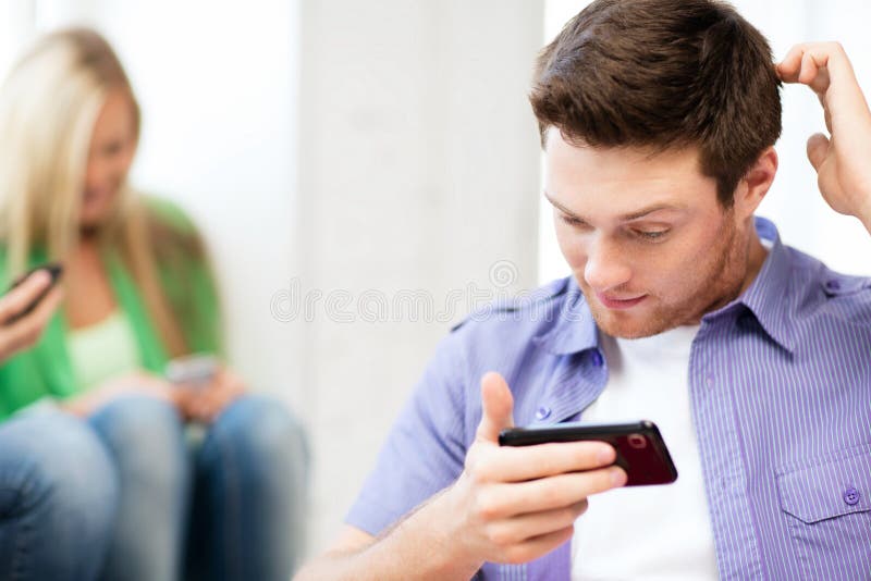 Student Looking at Phone and Writing Something Stock Image - Image of ...