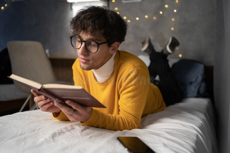Student Lying on a Bed and Studying with Focus and Concentration in ...
