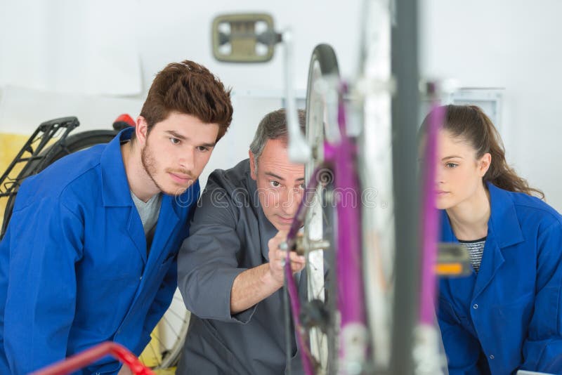 Student Mechanics Looking at Bicycle with Teacher Stock Photo - Image ...
