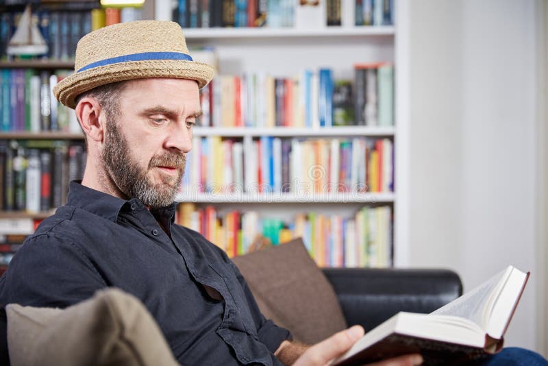 Student Mit Dem Hut, Der Vor Einer Buchregallesung Sitzt Stockfoto ...