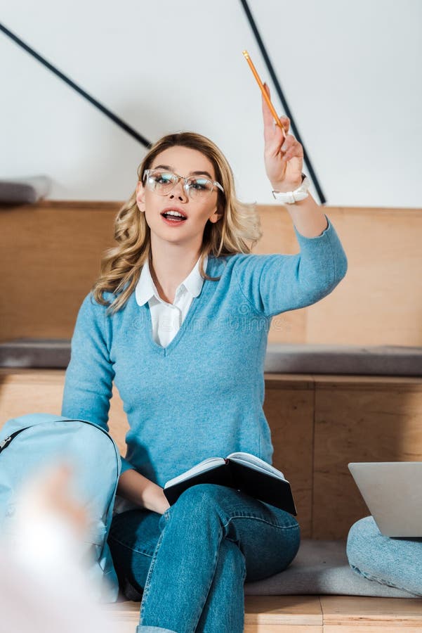 Student with Notebook Raising Hand in Lecture Hall Stock Image - Image ...