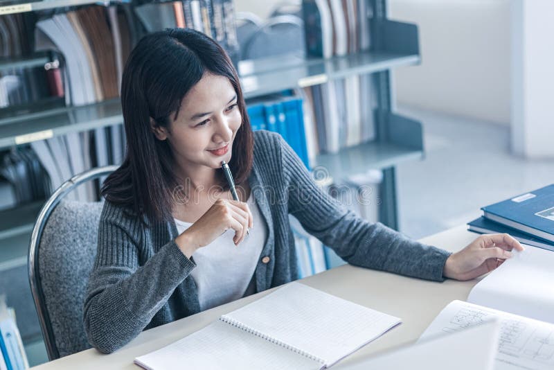 Student Open a Book and Read for Exam in the Library. Education Concept ...