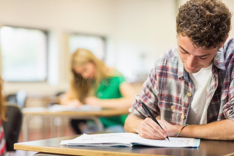 Student with Others Writing Notes in Classroom Stock Image - Image of ...