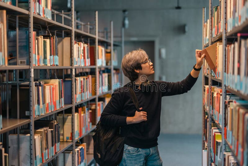 Student Picking Book from Bookshelf in Library Stock Photo - Image of ...