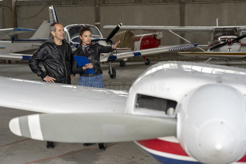 Student Pilot and Instructor Check an Aircraft for Safety in a Hangar ...