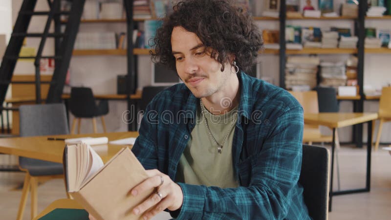 Young Man Student Reading a Book in the Library or Classroom ...