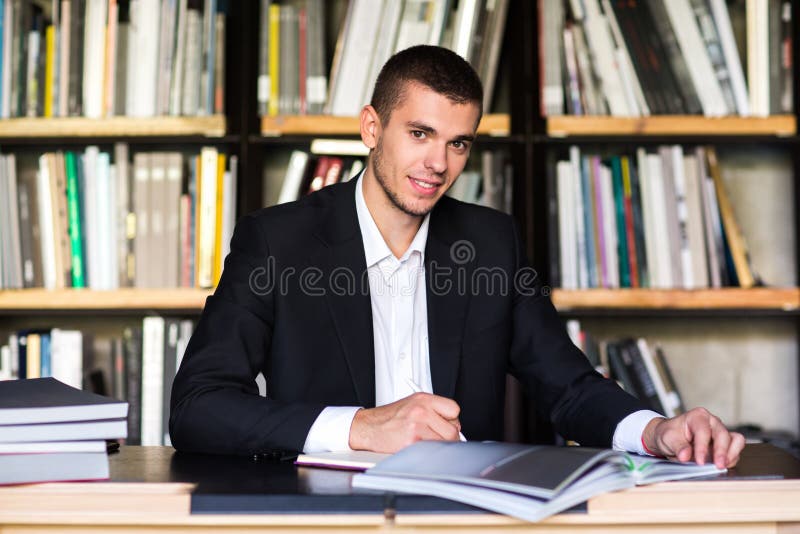 Student Reading a Book in the Library. Guy Reading a Book in a Library ...