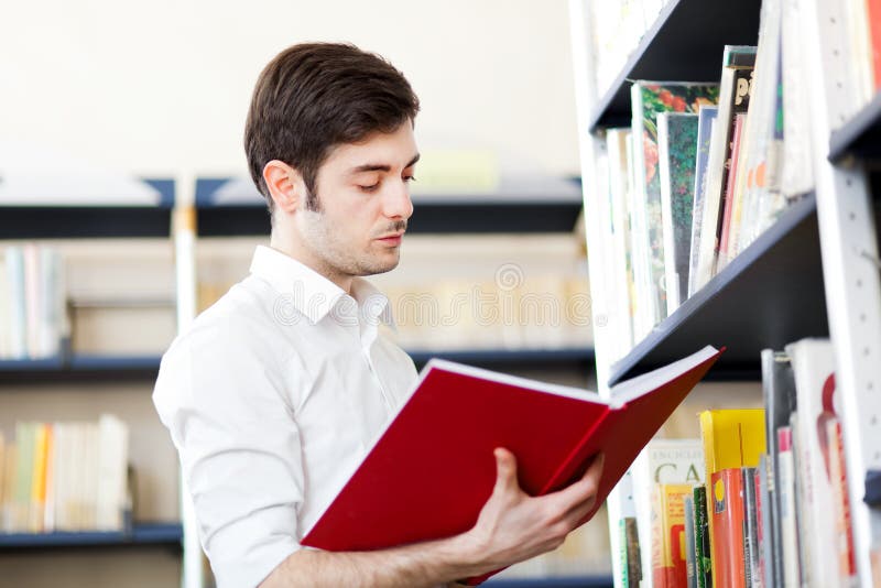 Student Reading a Book in a Library Stock Photo - Image of research ...