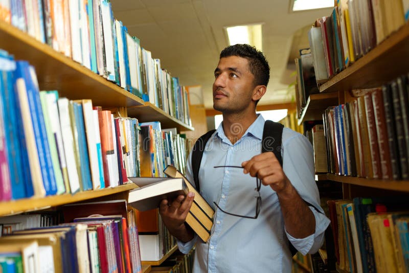 Student Reading Book between the Shelves in the Library Stock Image ...