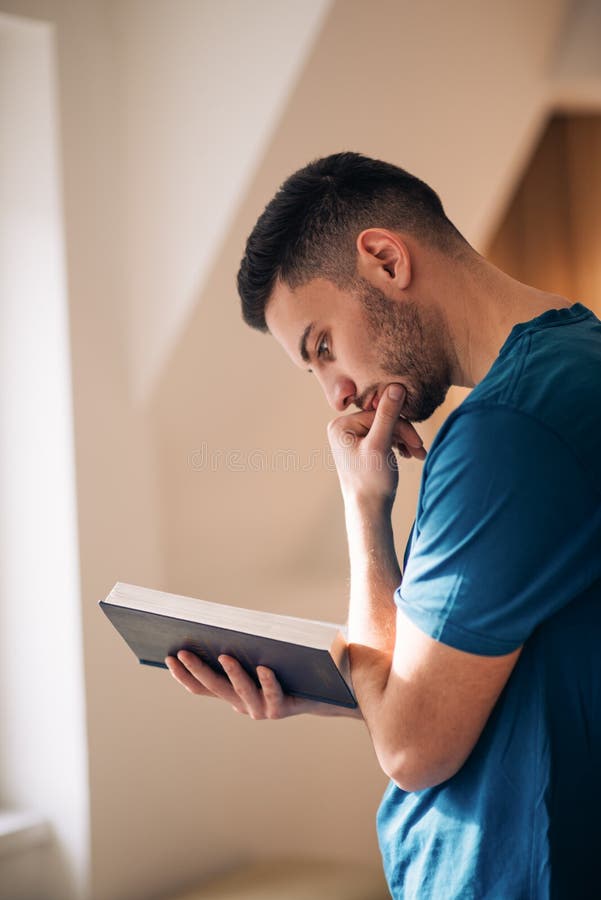 Student Reading a Book while Standing and Walking in the Room Next To ...