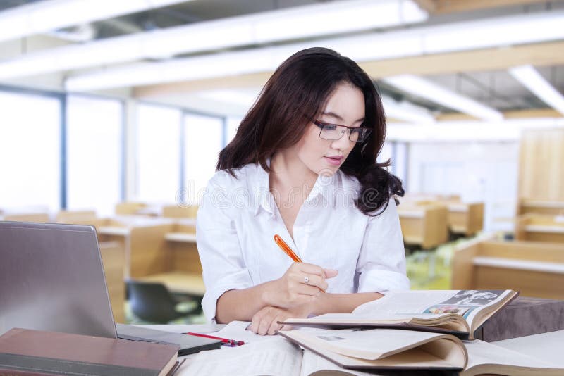 Student Reading Literature While Writing On Book Stock Photo - Image of ...