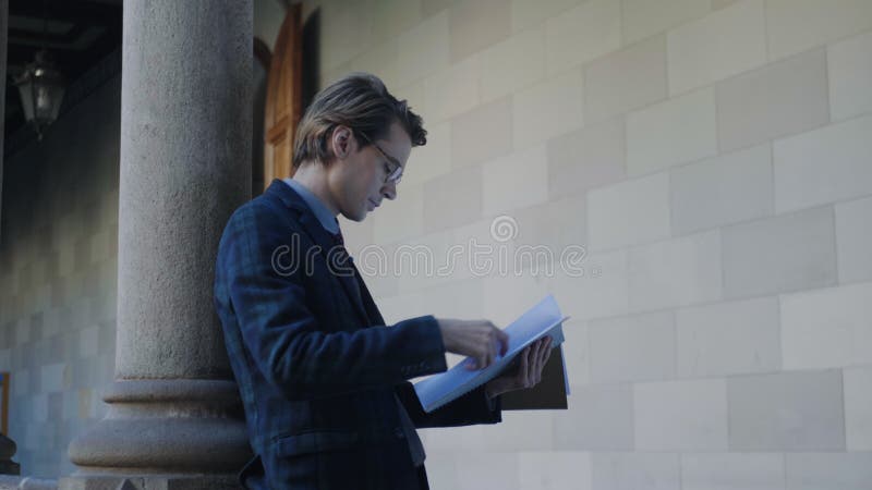 Student Reading Notes in Notebook at University. Businessman Looking in ...