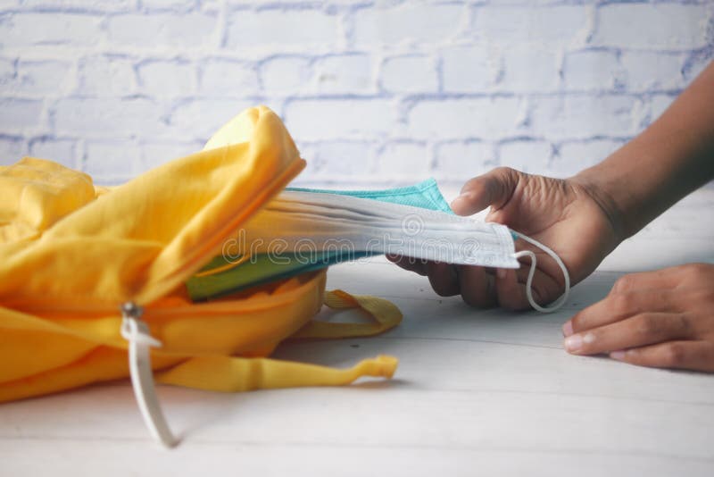 Putting Hand Sanitizer and Face Mask in a School Bag Stock Image ...