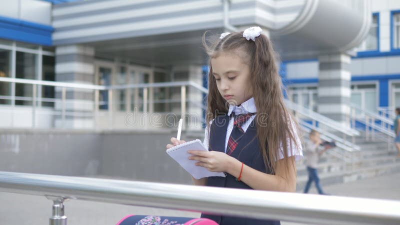 Student in School Uniform Near School Building Writes Something in a ...