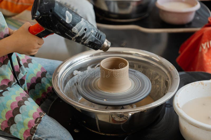 A Student Shapes Pottery on a Wheel during a Ceramics Class in the ...