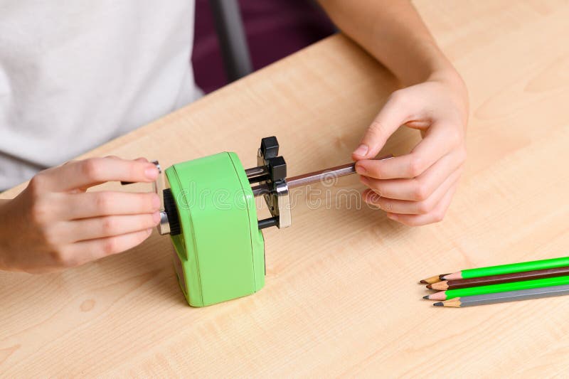 A Student Sharpens Pencils with a Sharpener. Stock Image - Image of ...