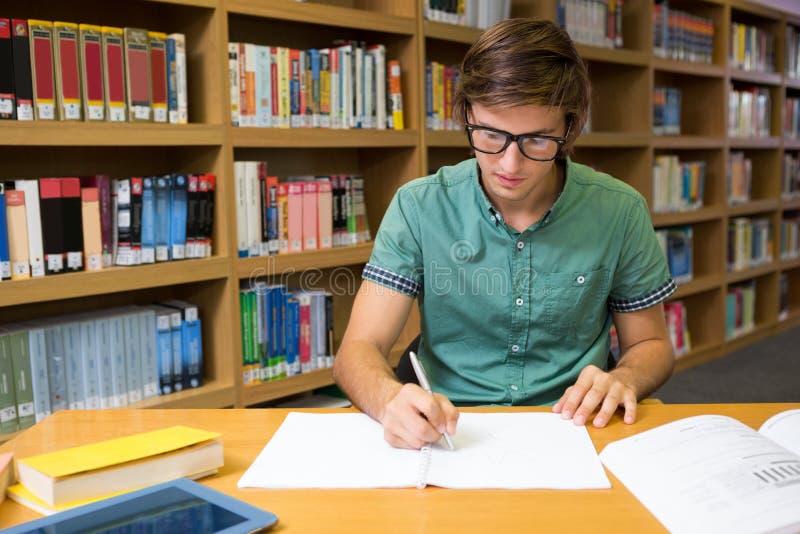 Student Sitting in Library Writing Stock Photo - Image of focused, book ...