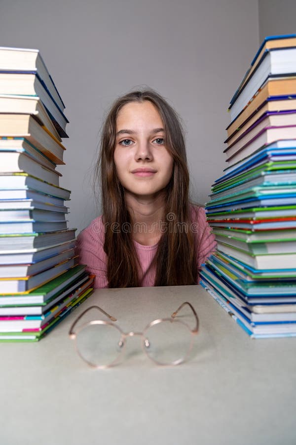 Student Sitting between Stacks of Books. a Young Girl Sitting between ...