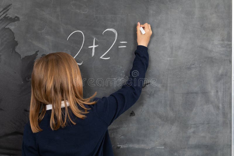 The Student Solves a Math Problem Standing at the Blackboard in Her ...