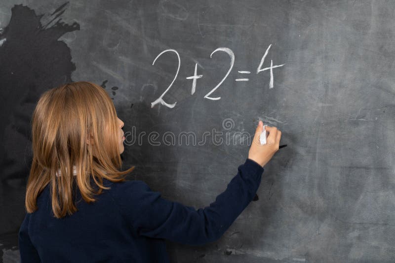 The Student Solves a Math Problem Standing at the Blackboard in Her ...