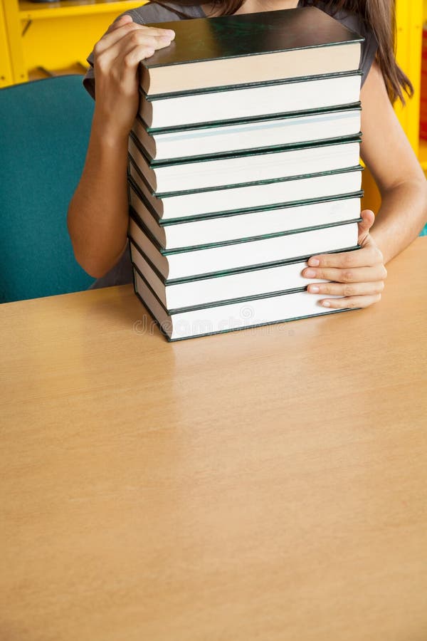 Student with Stacked Books Smiling at Table in Stock Photo - Image of ...