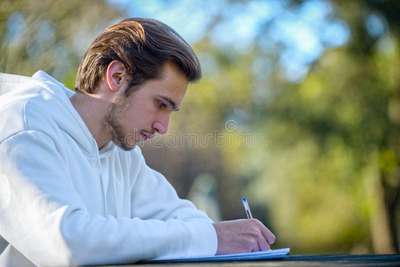 Student Studies in Nature. a Young Guy is Studying Outdoors Sitting in ...