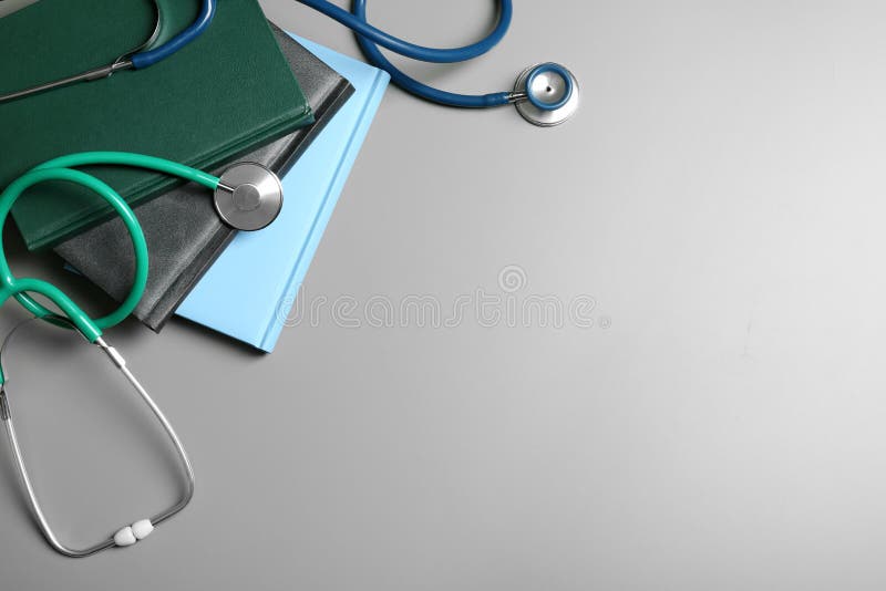 Student Textbooks, Stethoscopes and Space for Text on Grey Background ...