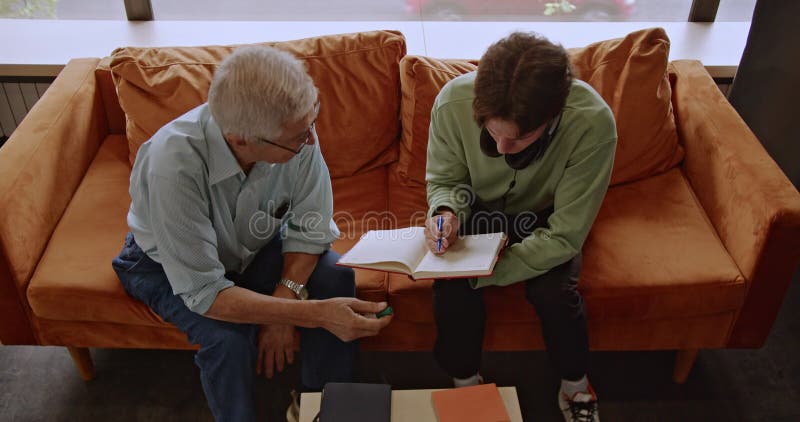 A Student and Professor are Working Together in the Library. they are ...