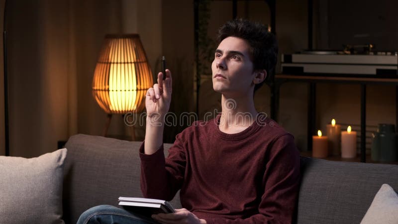 Student Thinking and Writing in a Notepad on the Sofa in the Living ...