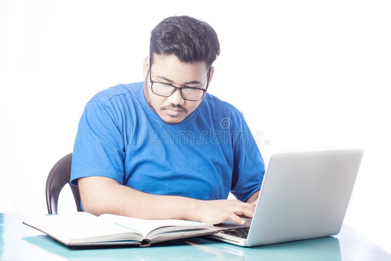 Young Man Typing on Laptop by Looking at Diary Book or Notepad Stock ...