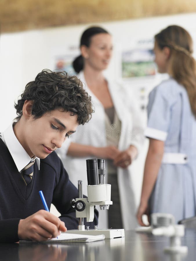 Student Using Microscope and Taking Notes in Laboratory Stock Photo ...
