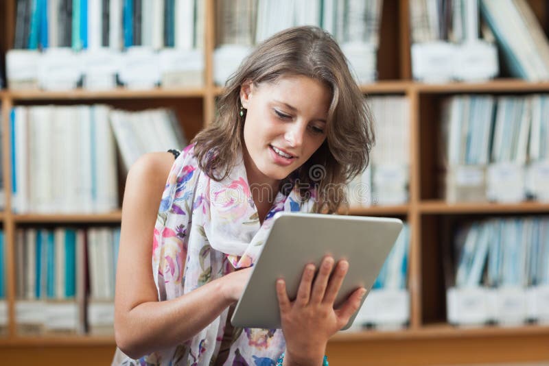 Student Using Tablet PC Against Bookshelf in Library Stock Image ...