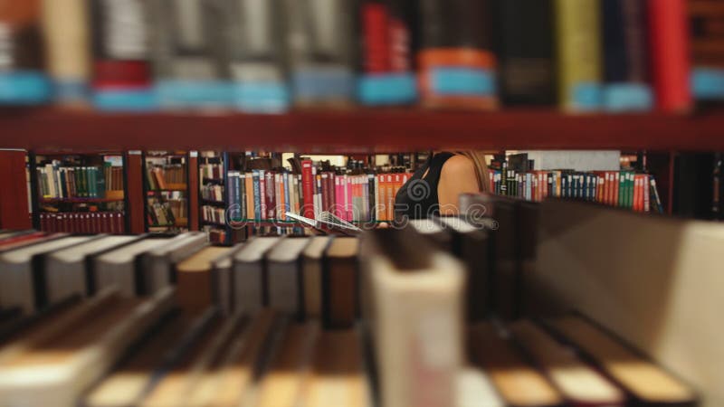 Student Walking through the Library and Reading a Book Stock Footage ...