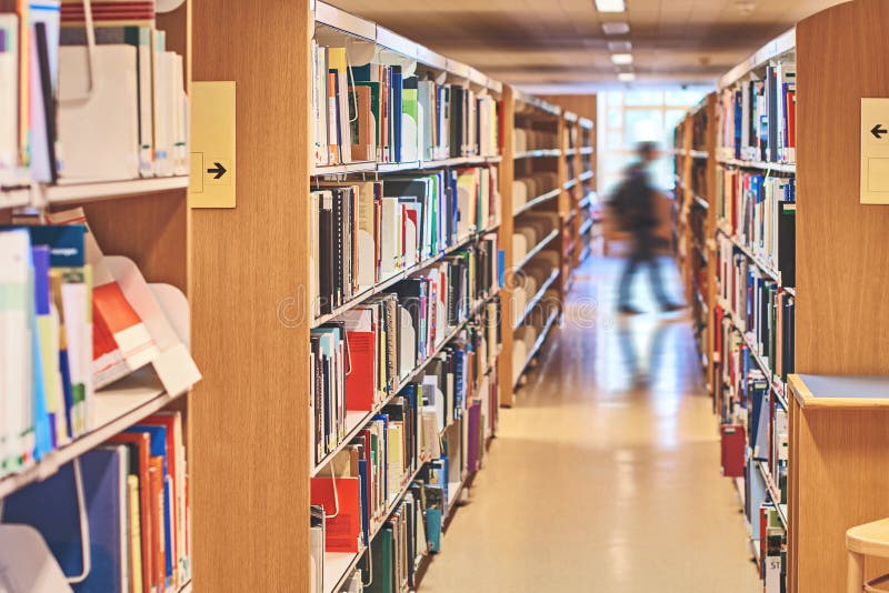 Student Walking through a Passage between the Bookcases in the Library ...