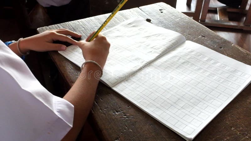 Student Writing Book on the Classroom at Elementary School Stock ...