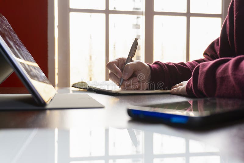 Student Writing Down Notes while Having an Online Lecture Stock Photo ...