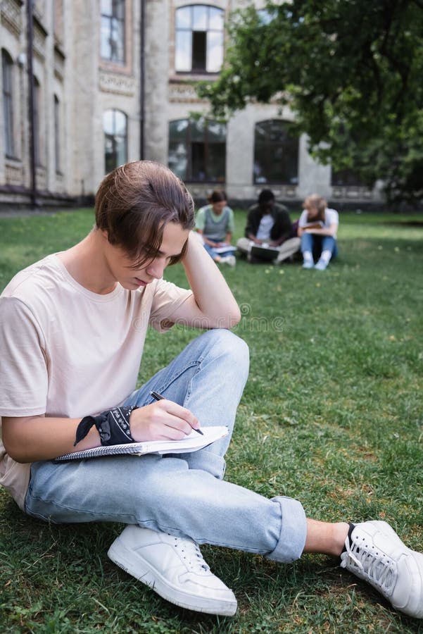 Student Writing on Notebook on Lawn Stock Photo - Image of people ...