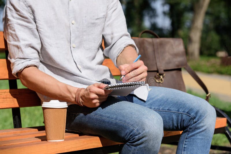 Student Writing in Notebook while Sitting on Bench in Park Stock Photo ...