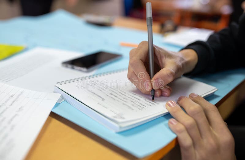Student Writing Notes on Desk in Classroom Stock Image - Image of table ...